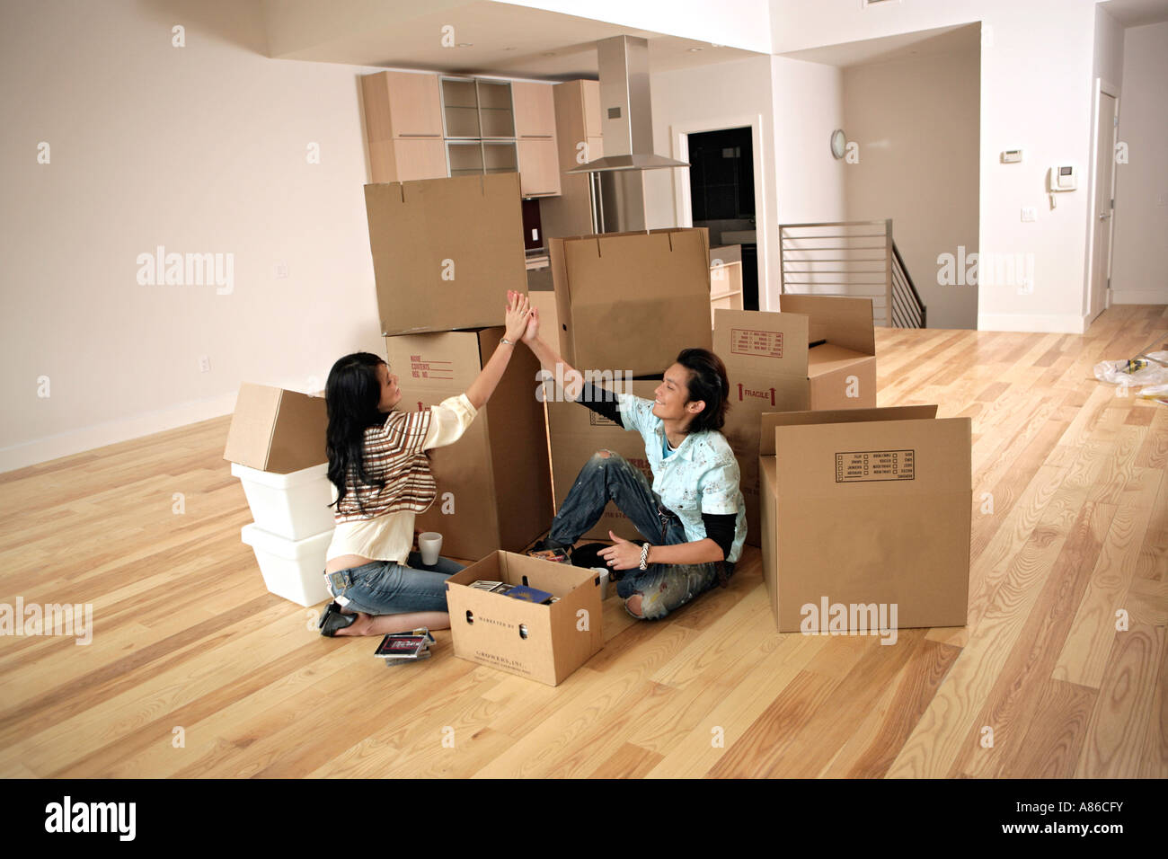 Couple joining hands beside boxes, side view Stock Photo - Alamy
