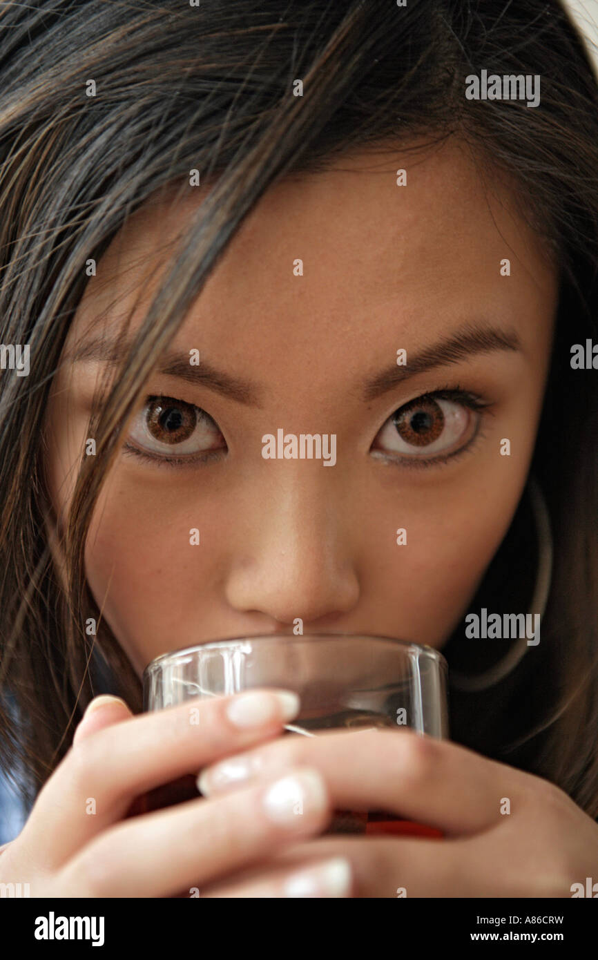 Young woman having beverage, portrait Stock Photo - Alamy