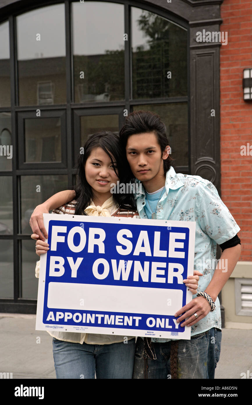 Young couple with advertisement board, portrait Stock Photo - Alamy