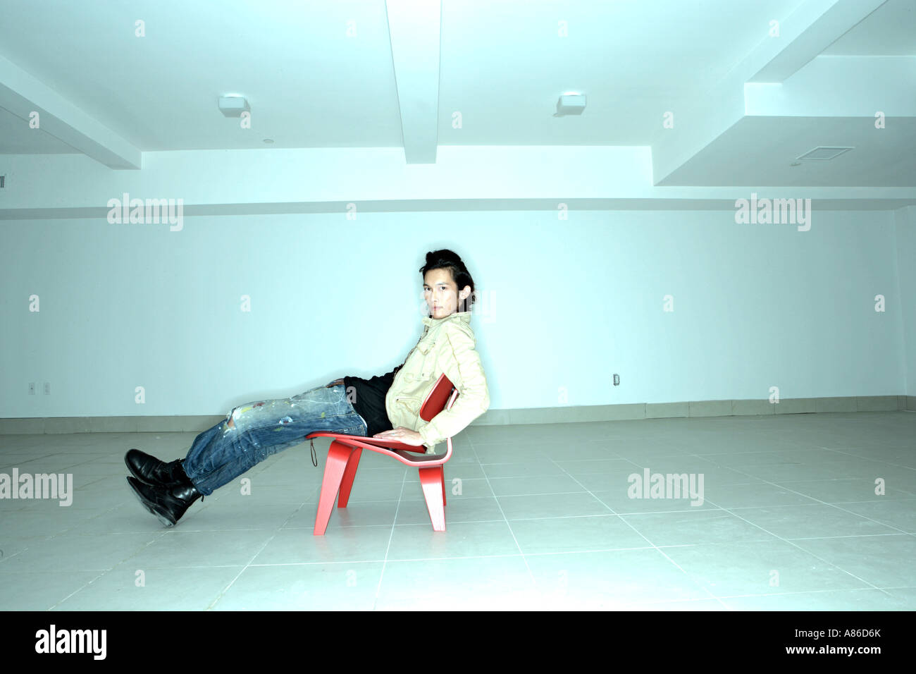 Young man seated on chair Stock Photo - Alamy