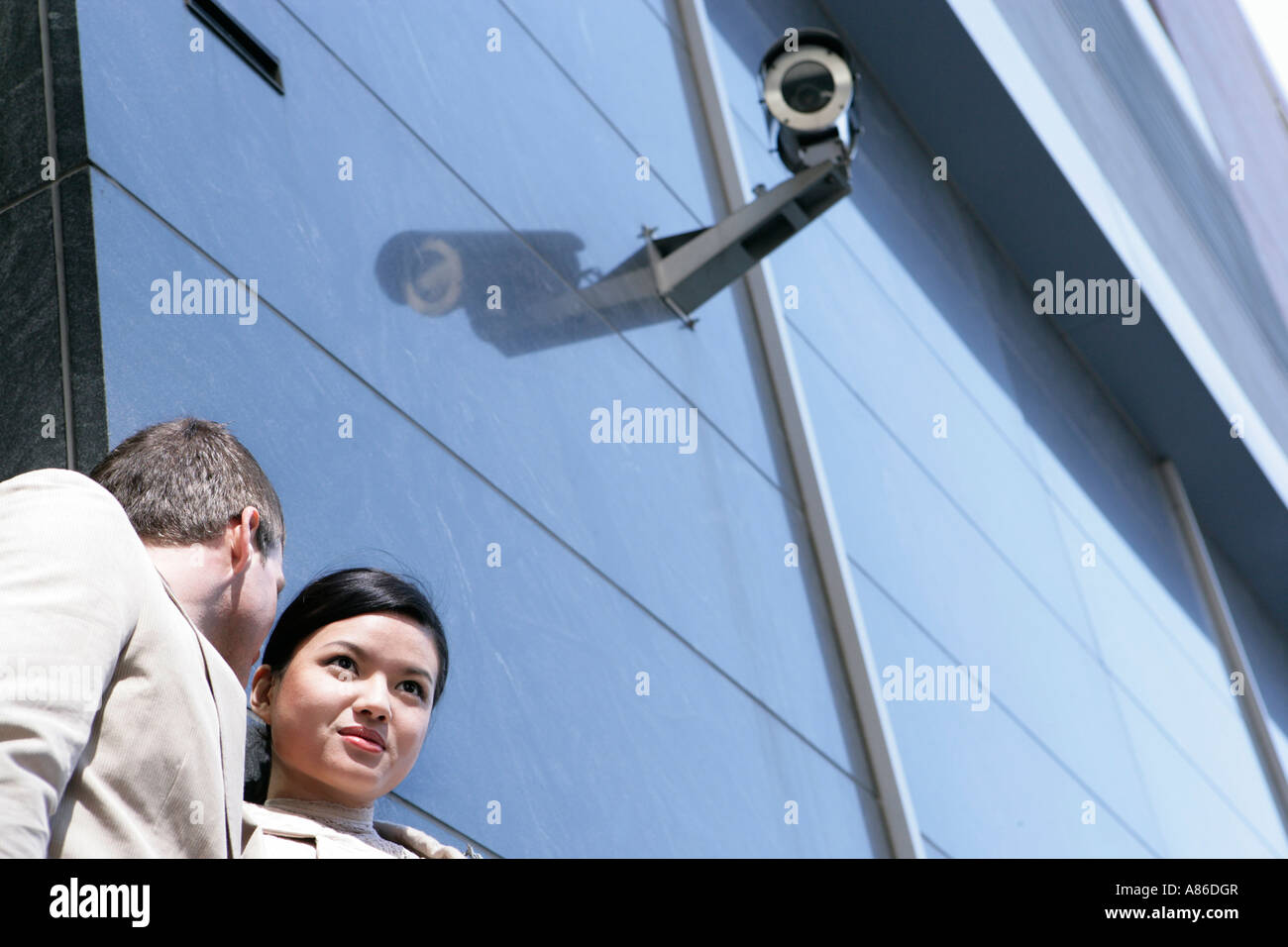 Man saying something in a young woman's ear Stock Photo - Alamy