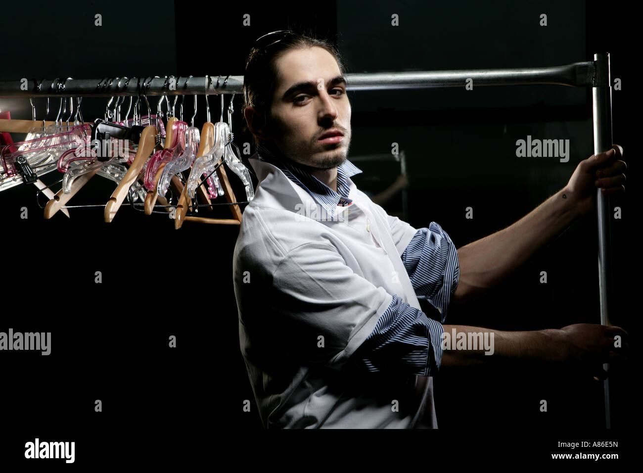 Young man holding a clothing rack Stock Photo - Alamy