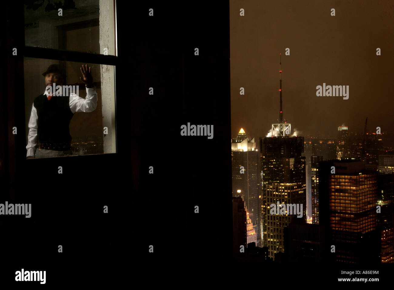 Young man standing at a window Stock Photo - Alamy