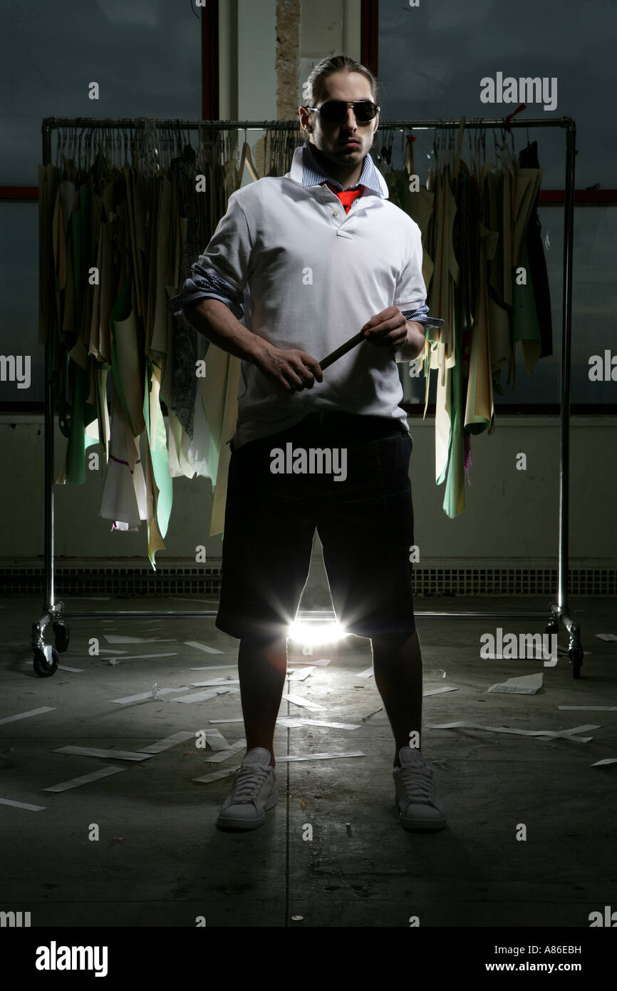 Young man in front of a clothing rack Stock Photo - Alamy