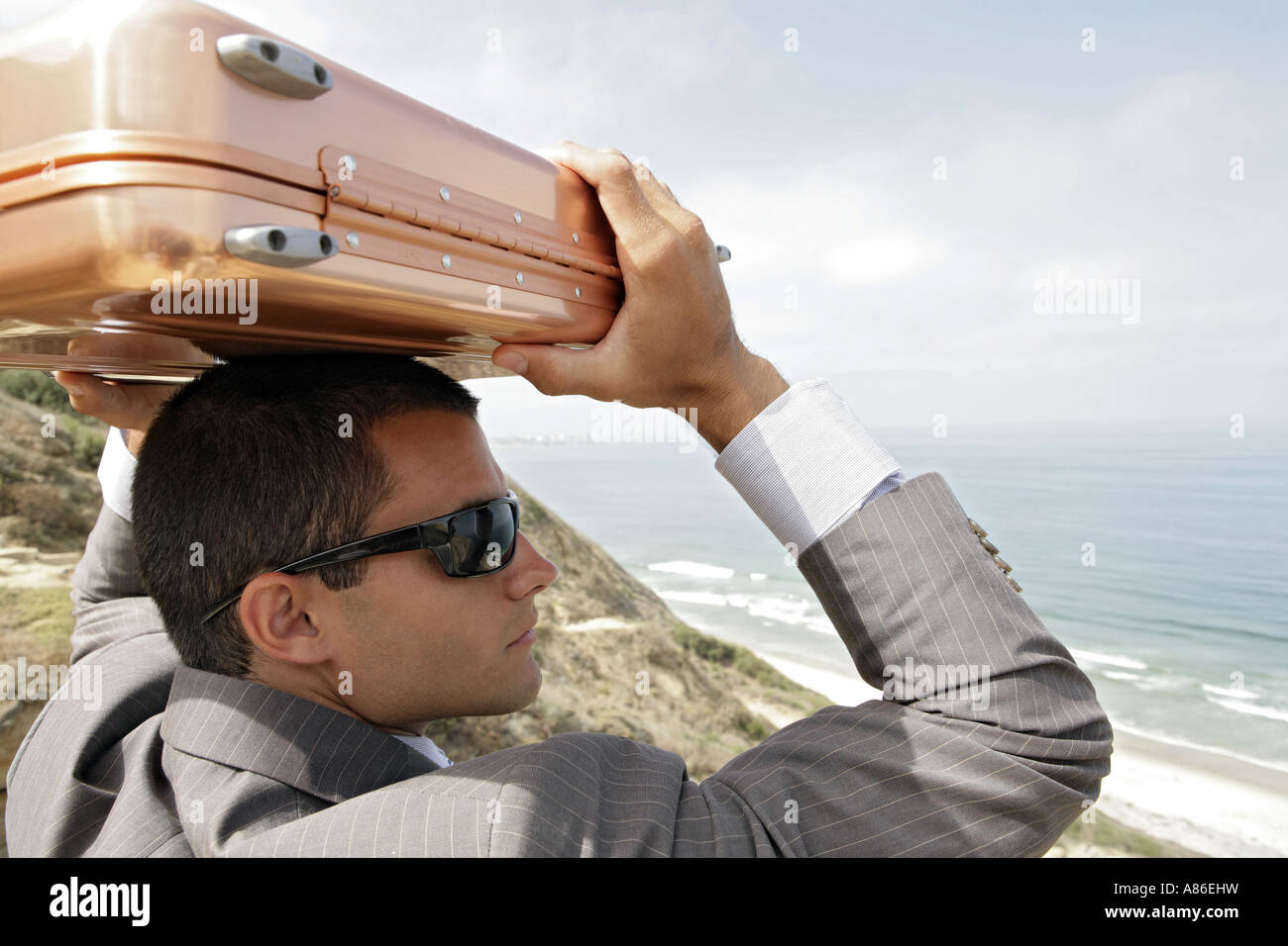 View of a man holding a briefcase on his head Stock Photo - Alamy