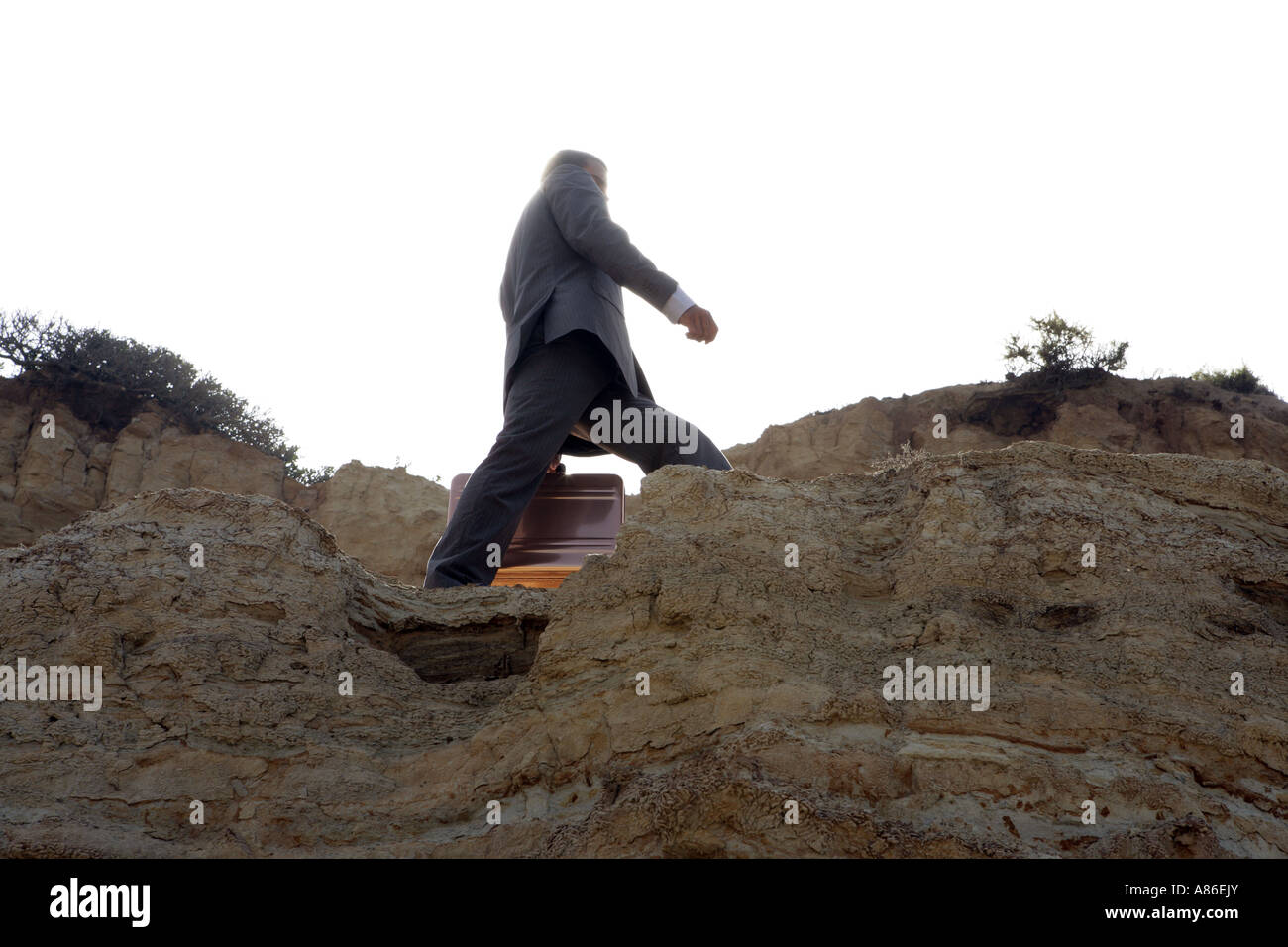 Business man walking on edge of cliff Stock Photo - Alamy