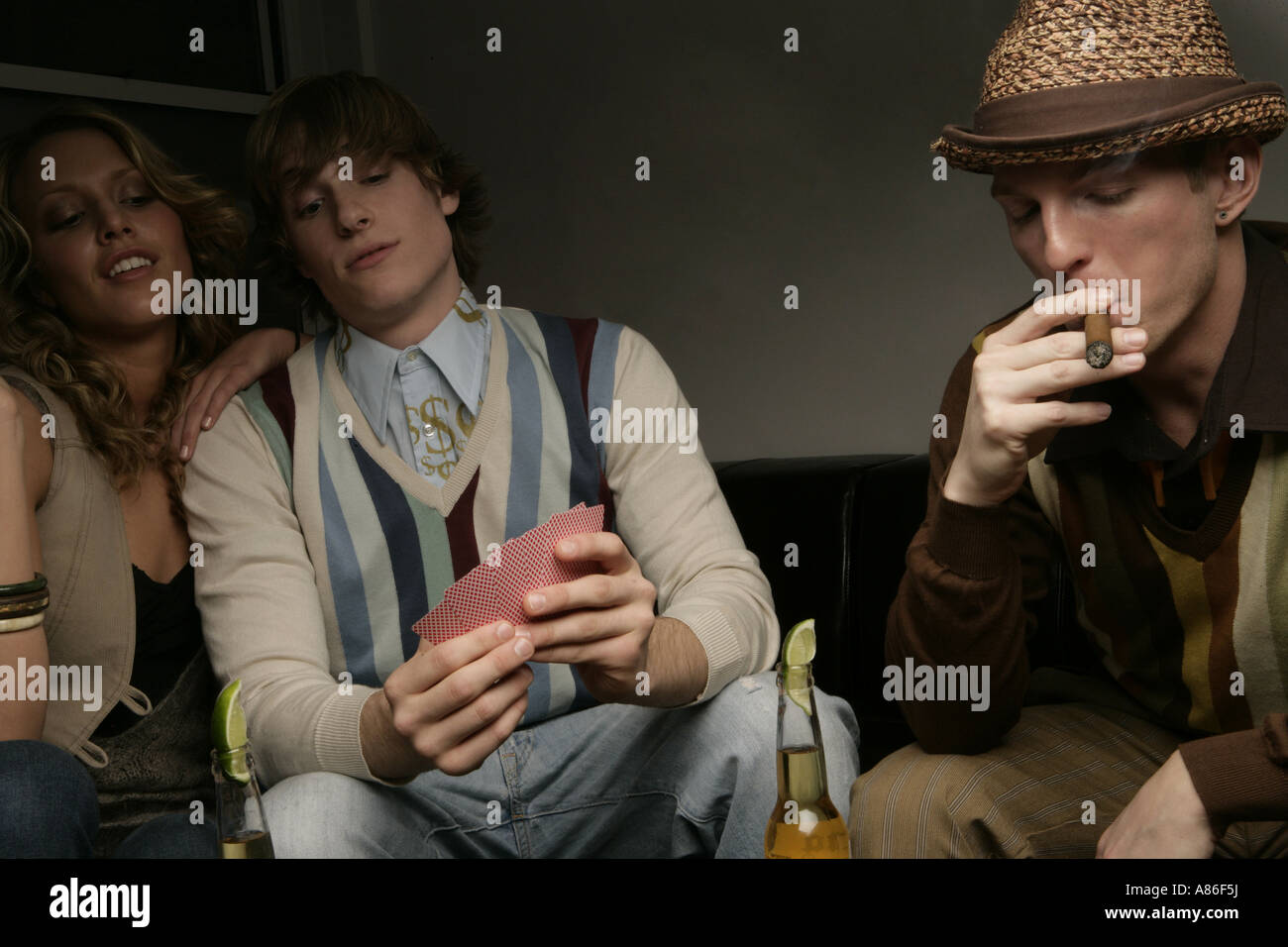 View of three people playing a card game Stock Photo - Alamy