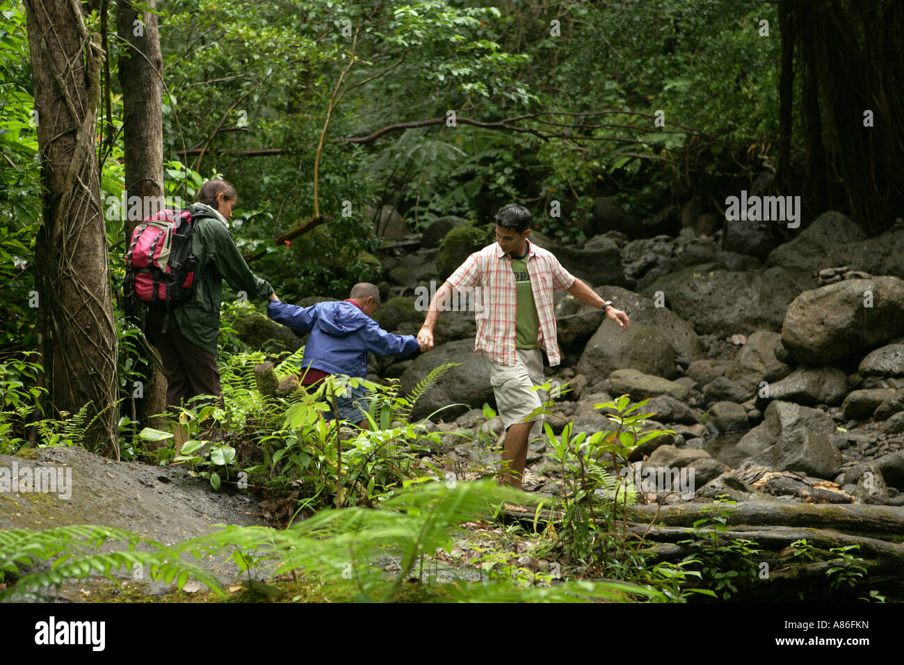 Two people helping child to cross a bridge Stock Photo - Alamy