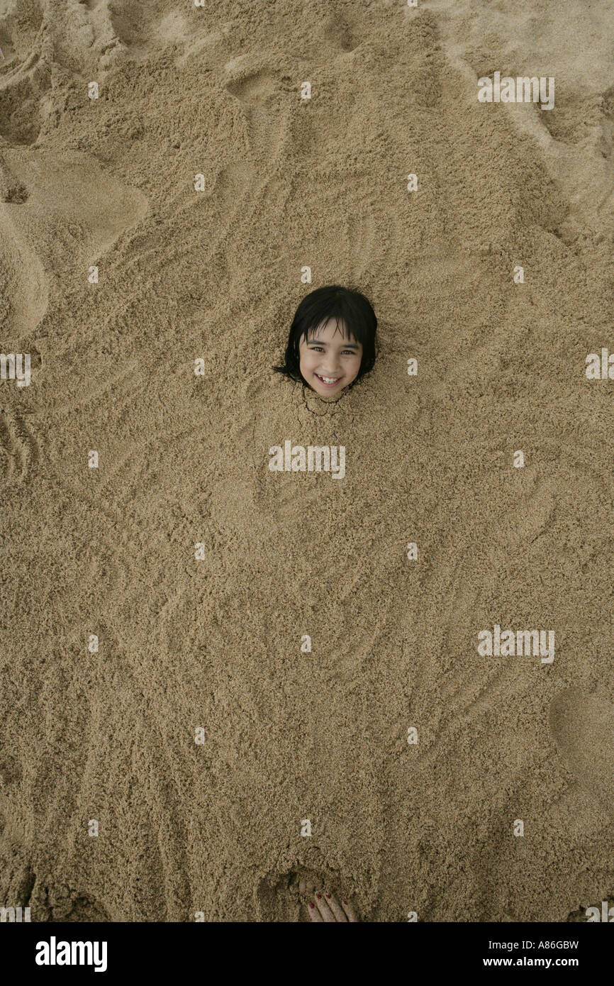 Girl buried in sand hi-res stock photography and images - Alamy