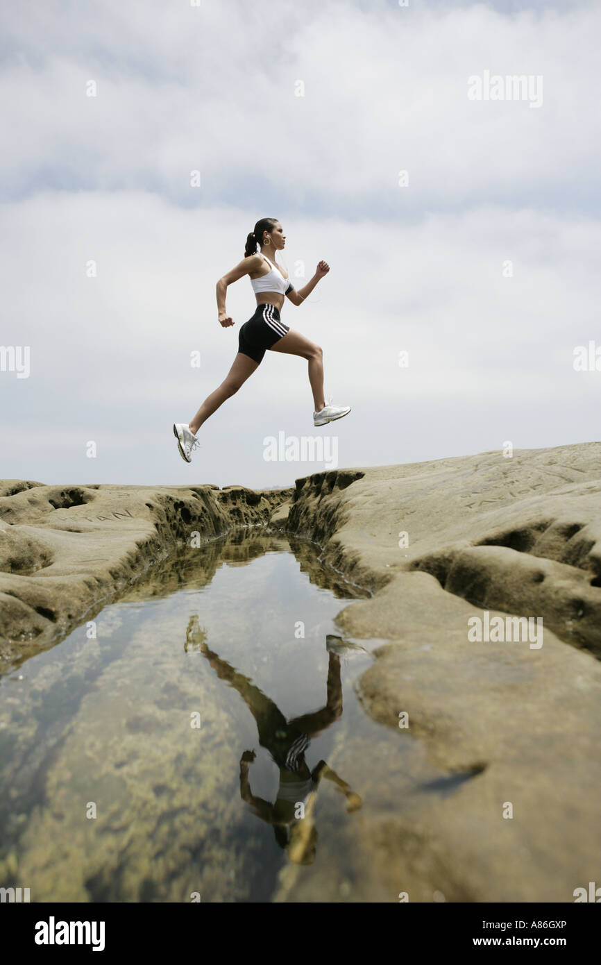 Woman leaping rocks hi-res stock photography and images - Alamy