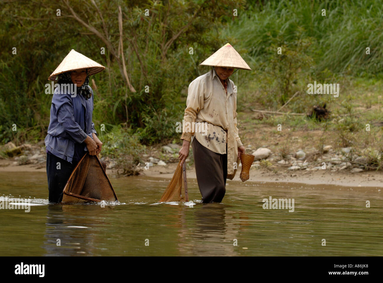 Two women fishing Nam Song River Vang Vieng Laos Stock Photo - Alamy