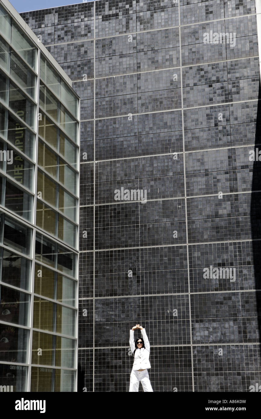 A young woman stands in front of a building Stock Photo - Alamy