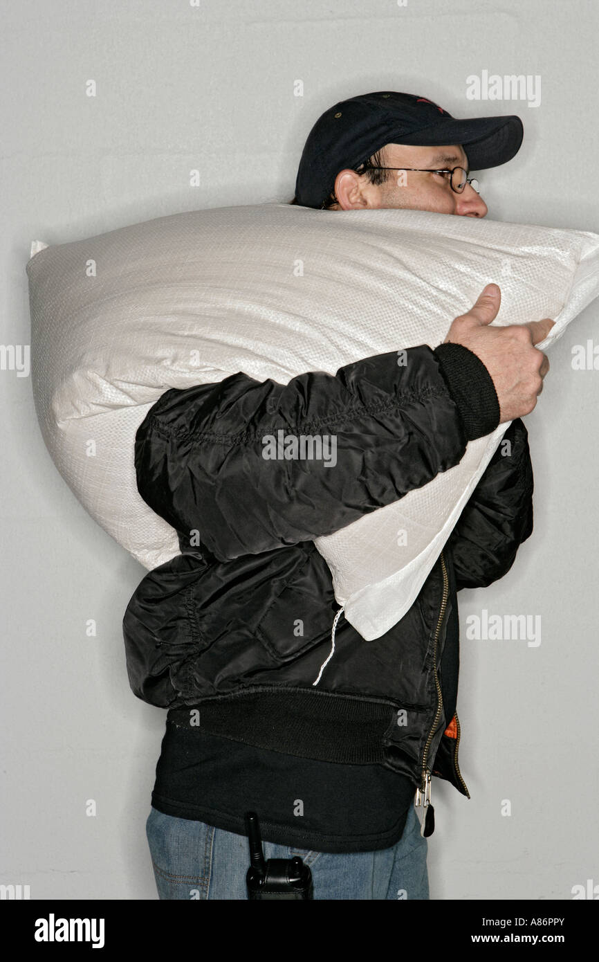 Man carrying heavy bags hi-res stock photography and images - Alamy