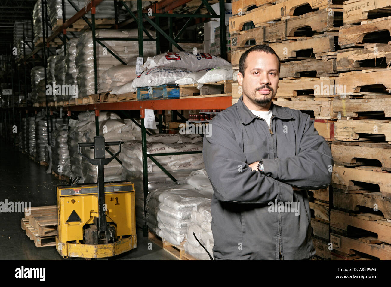 View of a man standing inside a warehouse Stock Photo - Alamy