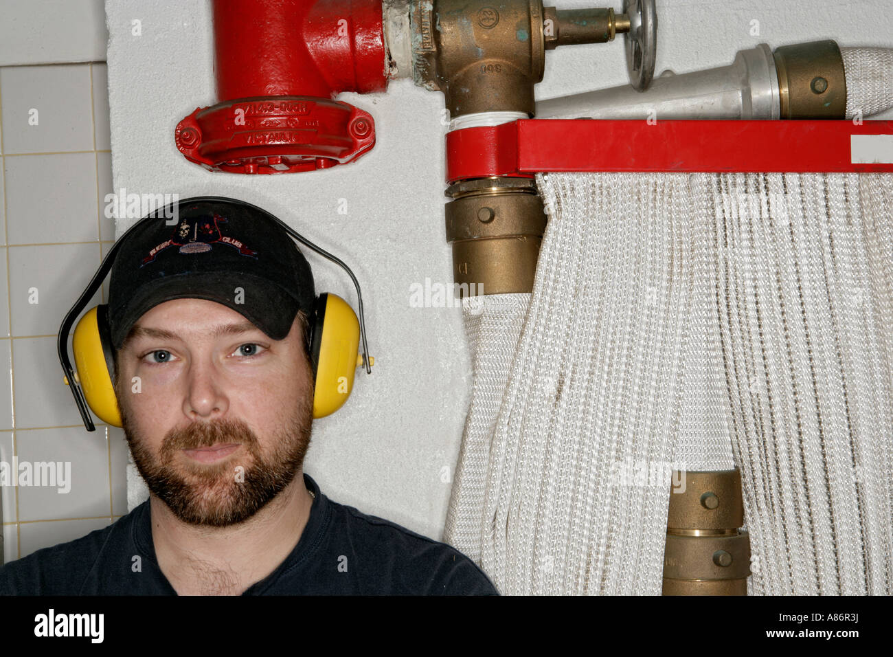View of a man standing in front of a fire extinguisher Stock Photo - Alamy
