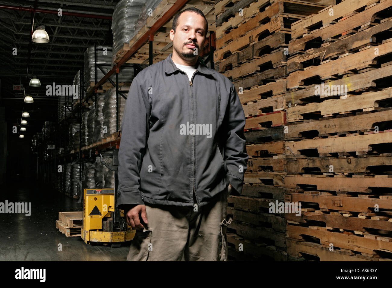 View of a man standing inside a warehouse Stock Photo - Alamy
