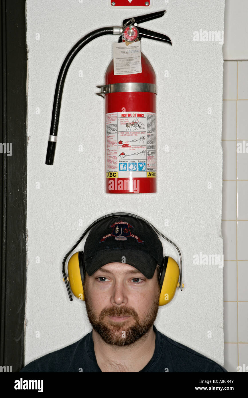 View of a man standing in front of a fire extinguisher Stock Photo - Alamy