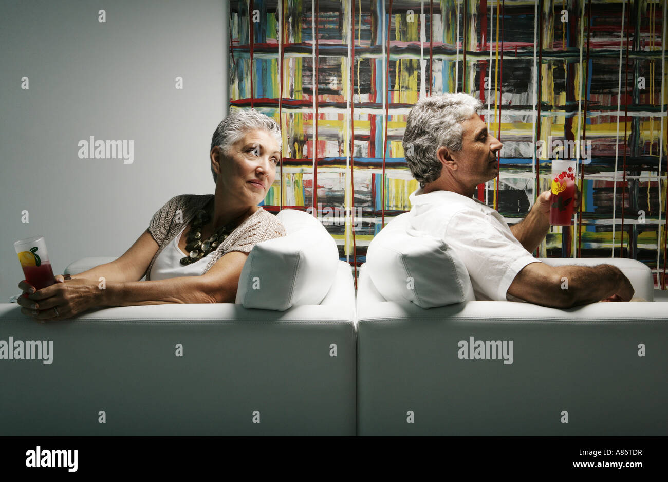 Man and woman sitting back to back Stock Photo - Alamy