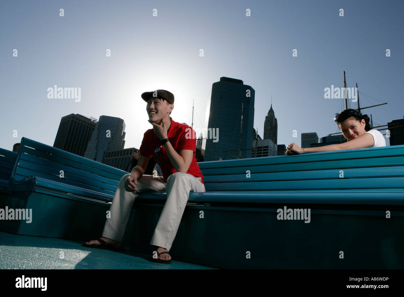 Two people sitting on benches smiling Stock Photo - Alamy