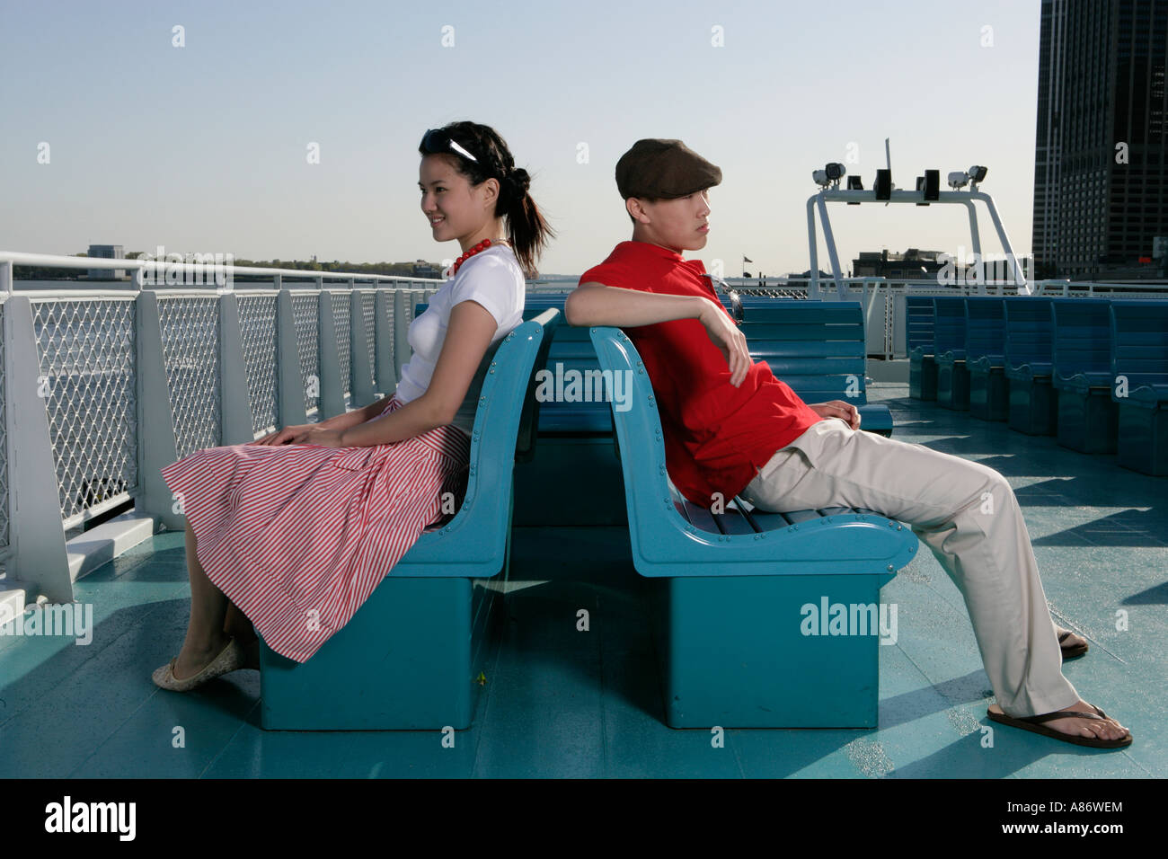 Two people sitting back to back Stock Photo - Alamy