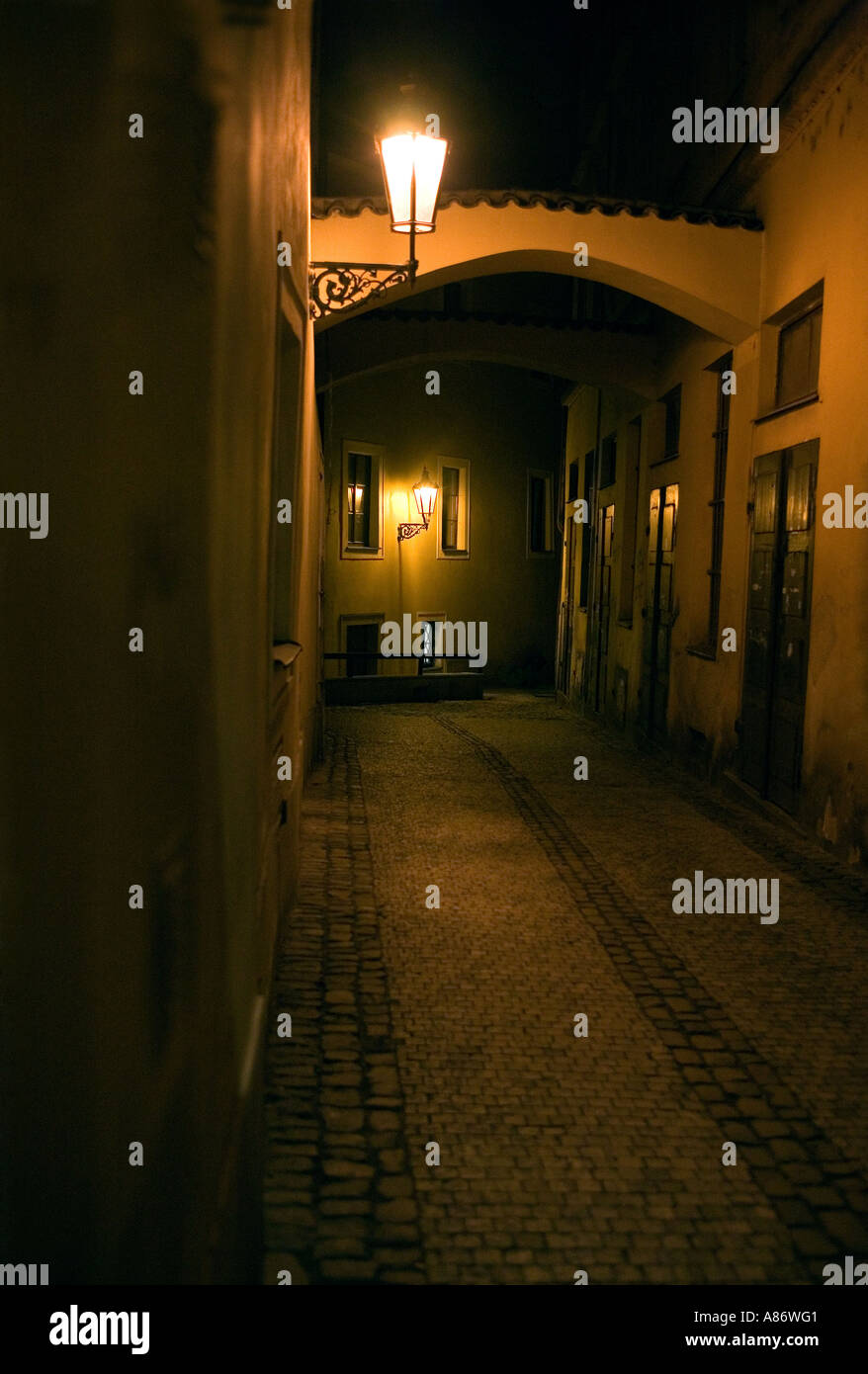 Old fashioned lamps lighting the way down old cobbled streets in Prague ...