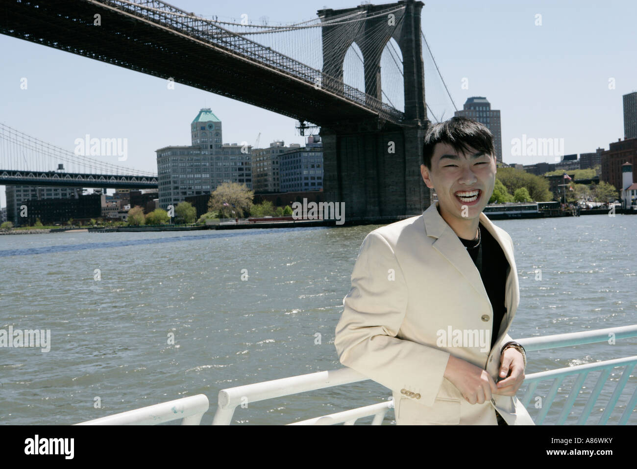 Man leaning on a railing with Brooklyn Bridge in the background Stock ...