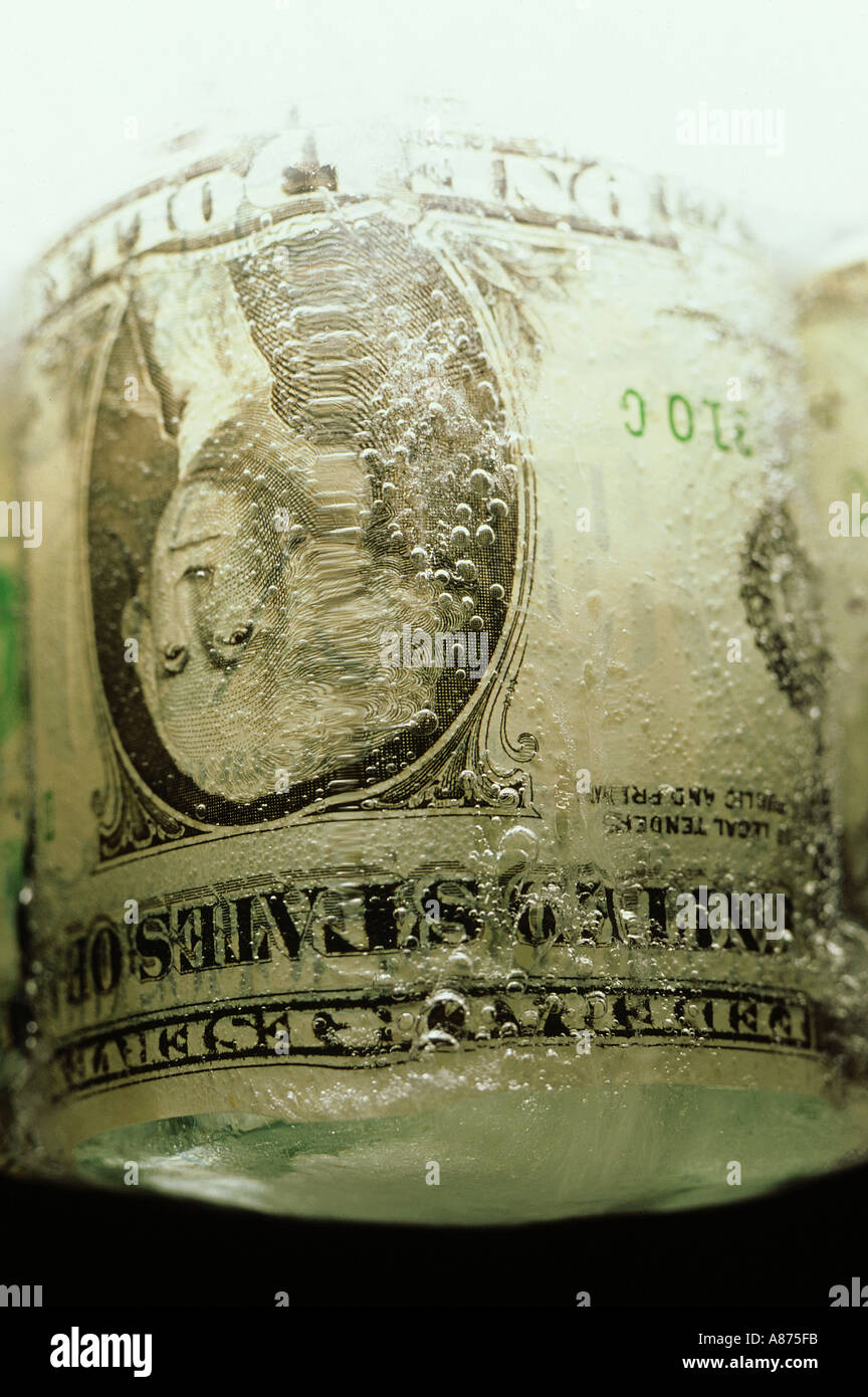 US Currency frozen in ice symbolizing "Frozen Assets Stock Photo - Alamy