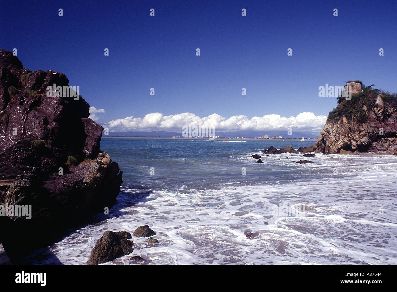 Two rock formations framing the incoming ocean waves spilling onto the ...