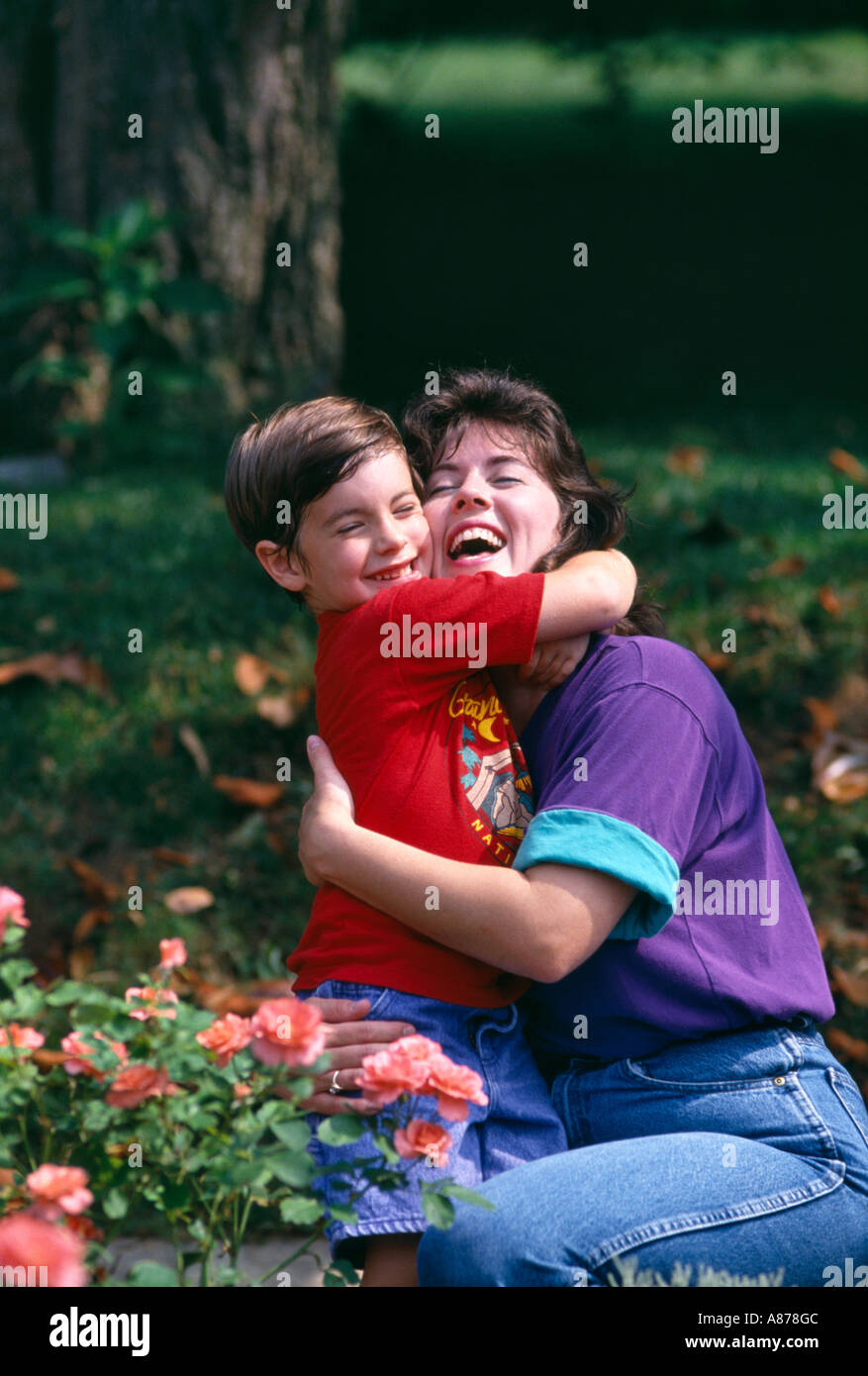Joyous Hug mom and son embrace in summer sun while enjoying garden ...