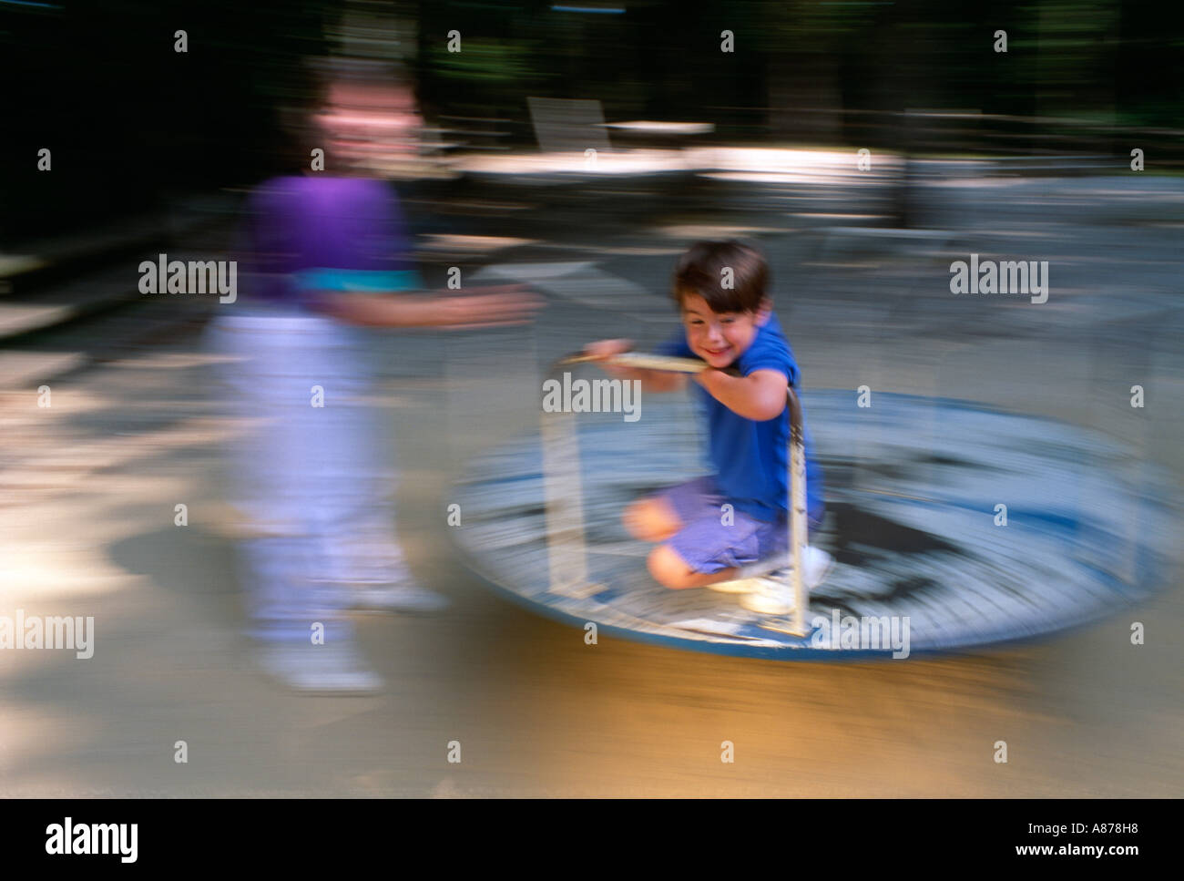 Children playing on spinning ride outdoors MR Stock Photo - Alamy