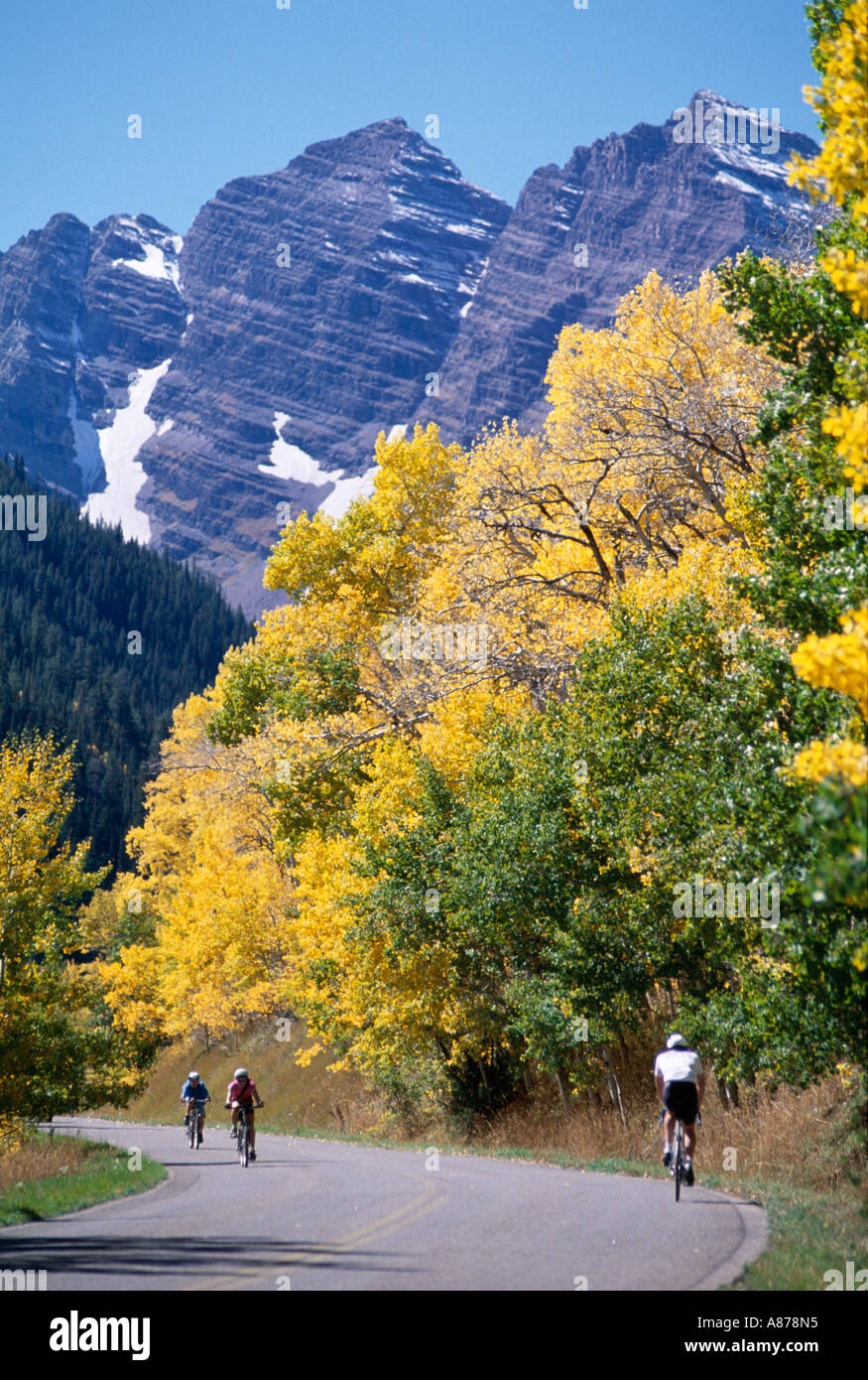 Three people riding bicycles through Aspen trees and mountains in the ...