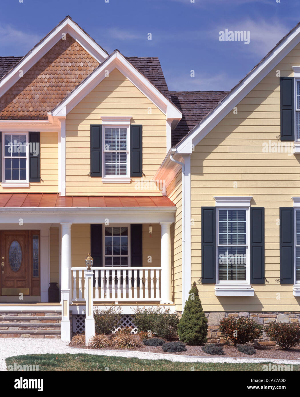 Tight shot of a large yellow painted multi story frame house with ...