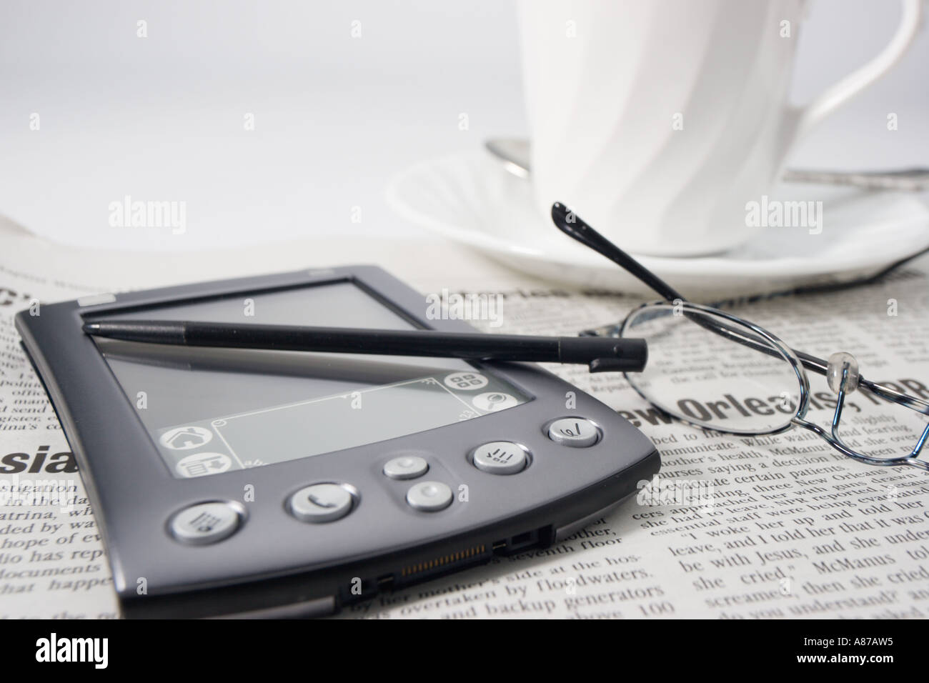 Reading morning newspaper with PDA and a cup of coffee Stock Photo - Alamy