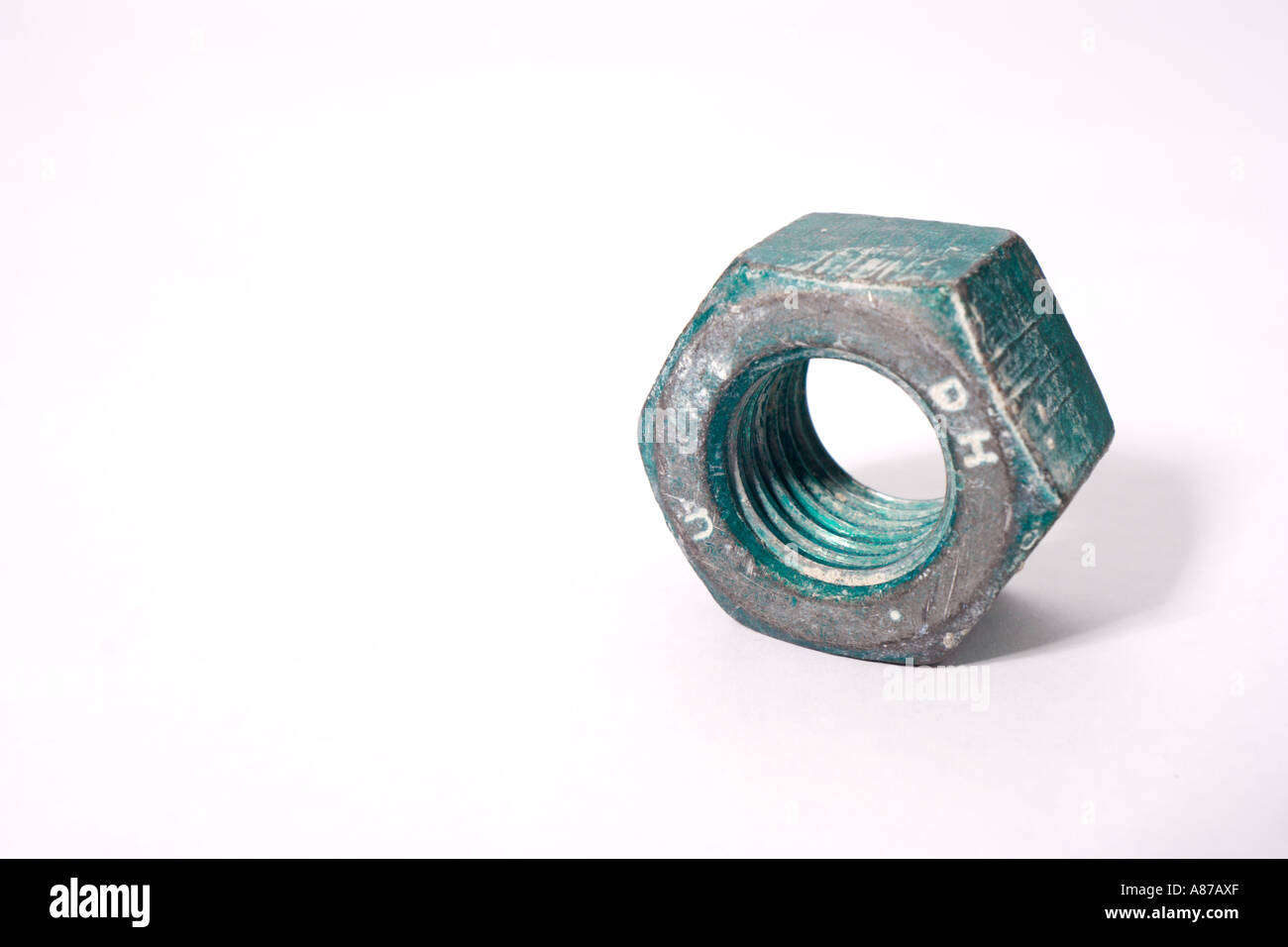 Large heavy duty steel mechanical nut standing on edge with white ...