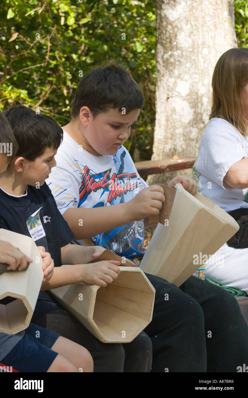 Young boys sanding wooden drums for painting at homeschool drum ...