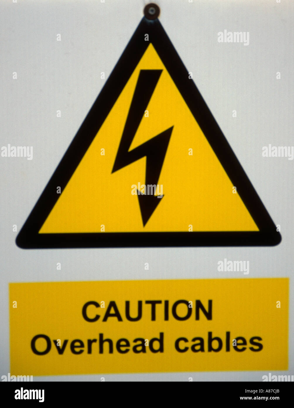 Yellow caution overhead cables sign warning of the risk of ...