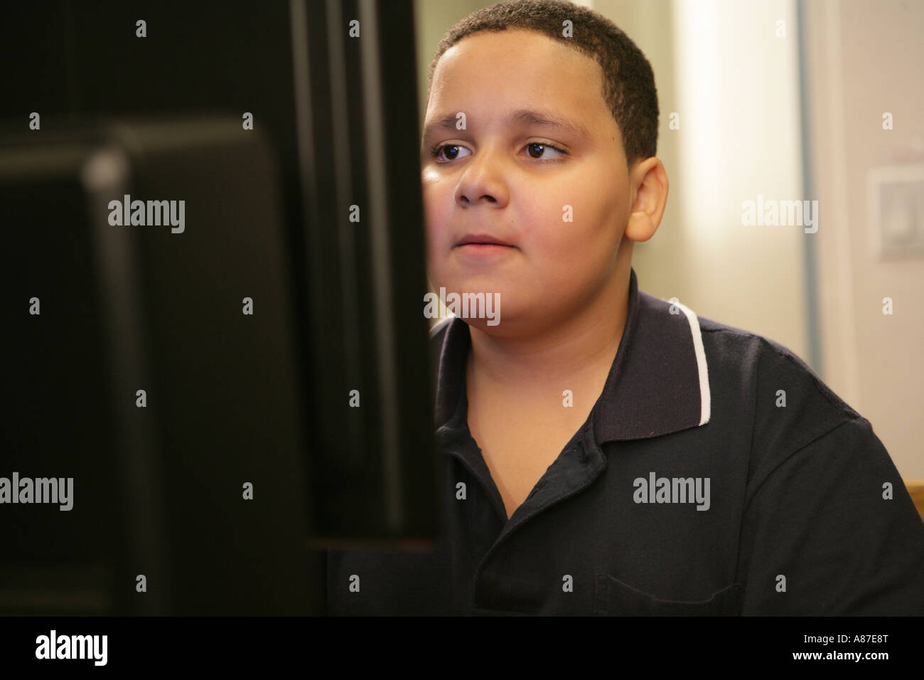 Boy (11-13) operating computer Stock Photo - Alamy