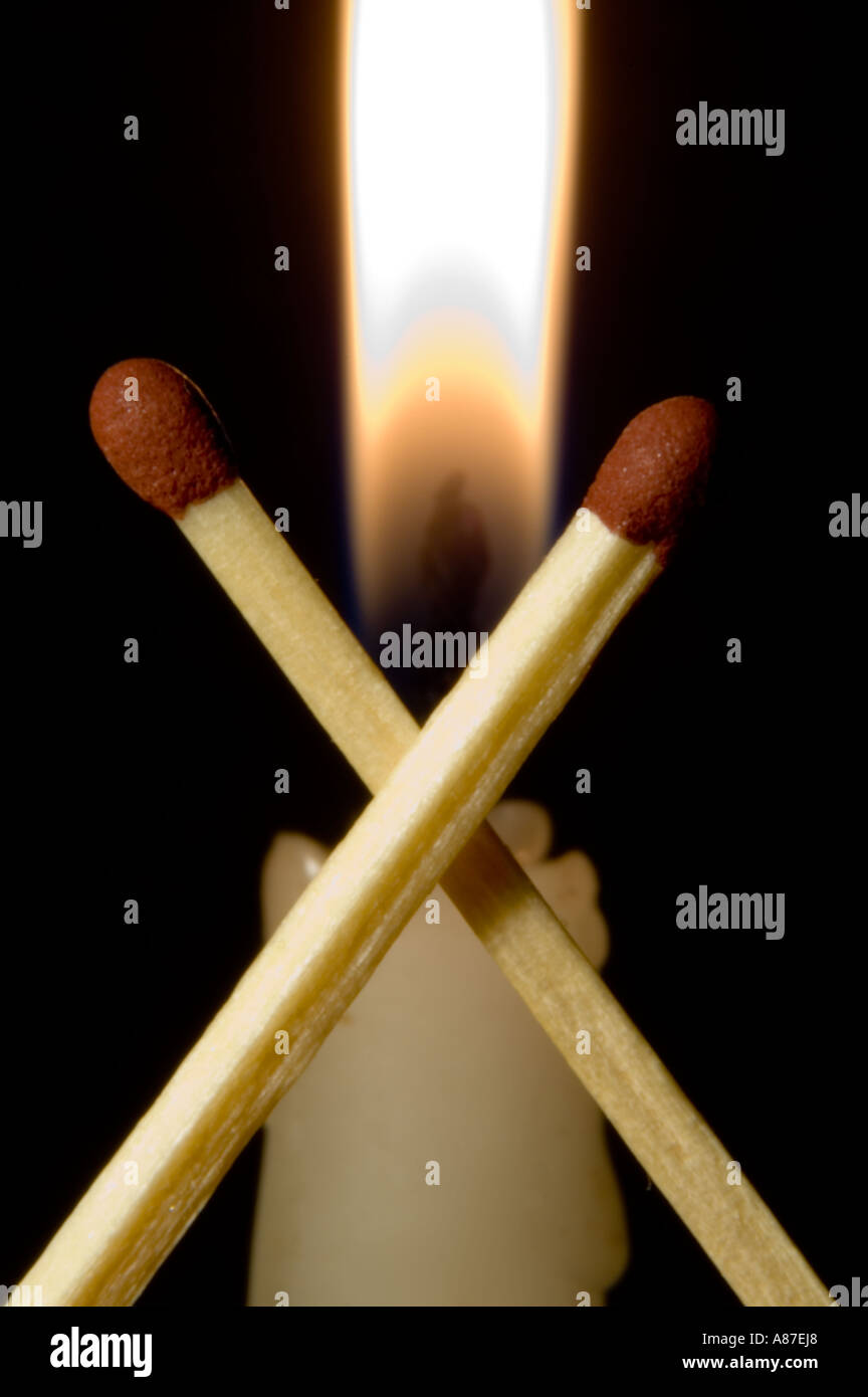 Two matches and a lit candle Stock Photo - Alamy