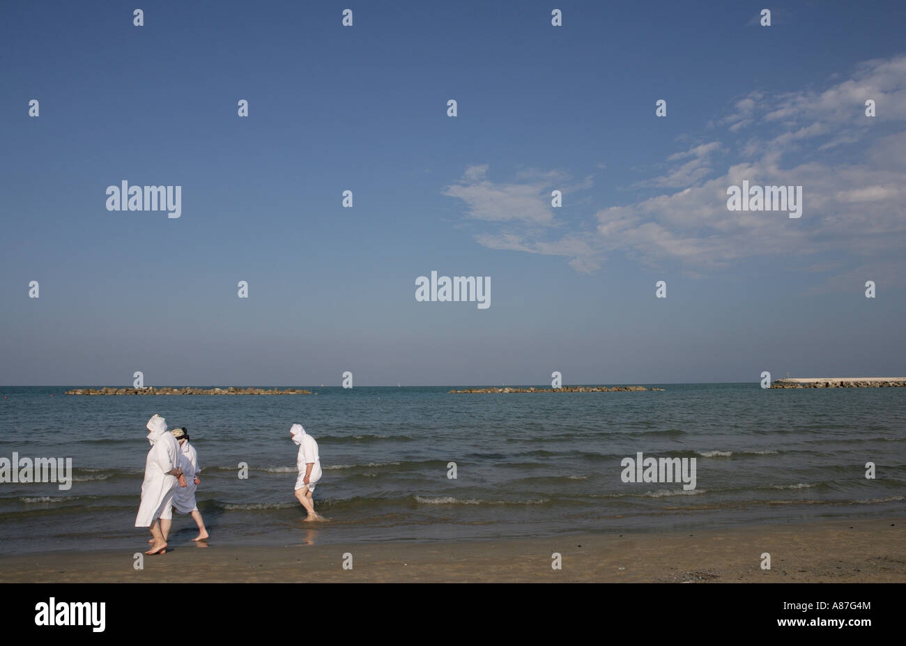 People walking on seashore Stock Photo - Alamy
