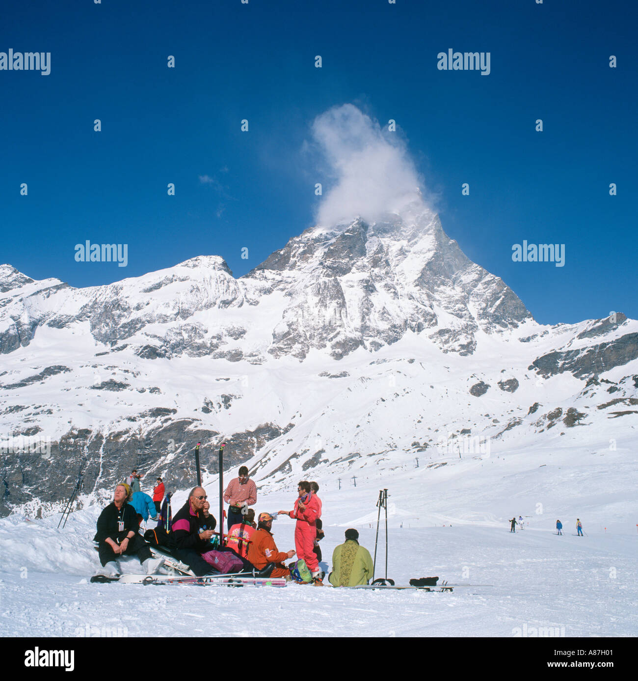 Skiers having a picnic lunch with the Matterhorn behind, Plan Maison ...