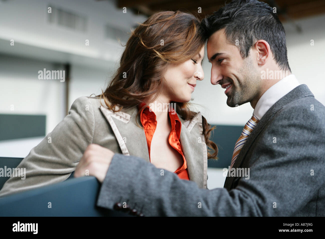 Two people smiling at each other in the office Stock Photo - Alamy