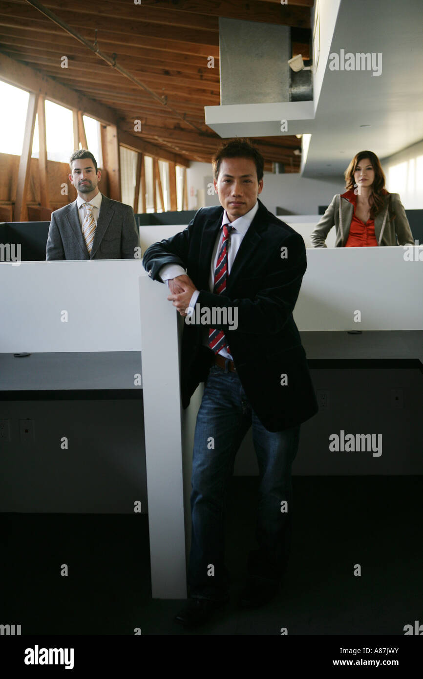 Three business people standing among cubicles Stock Photo - Alamy