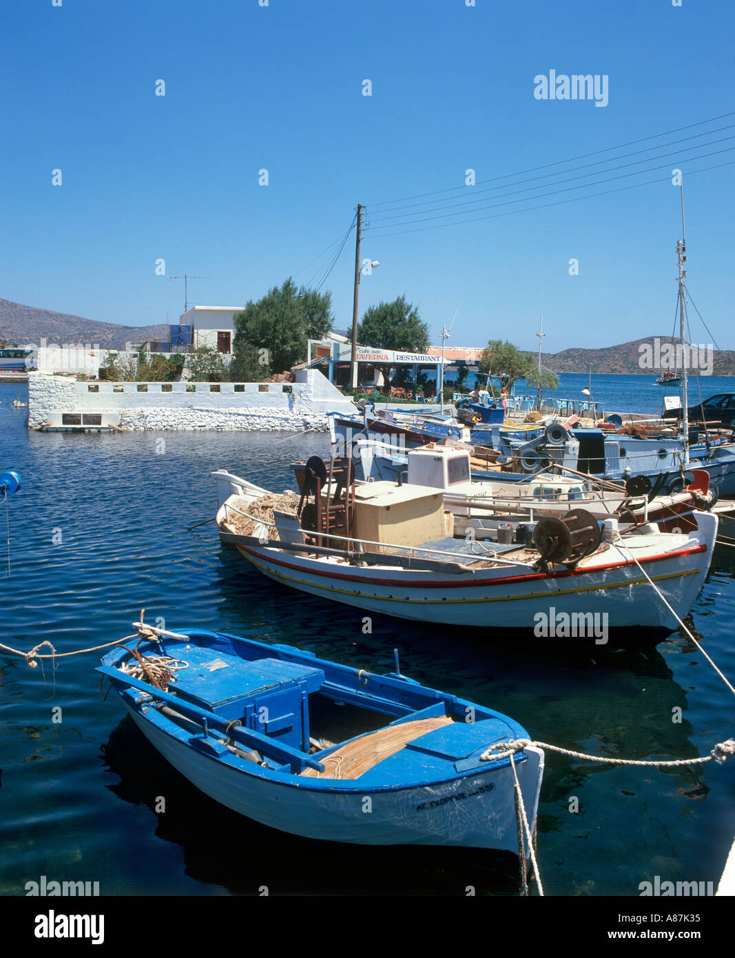 Fishing boats in the harbour with a taverna behind, Elounda, Crete ...