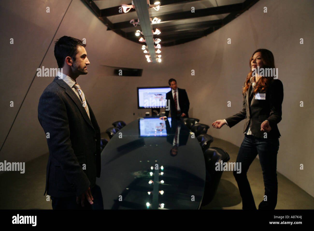 Three people inside a conference room having a discussion Stock Photo ...