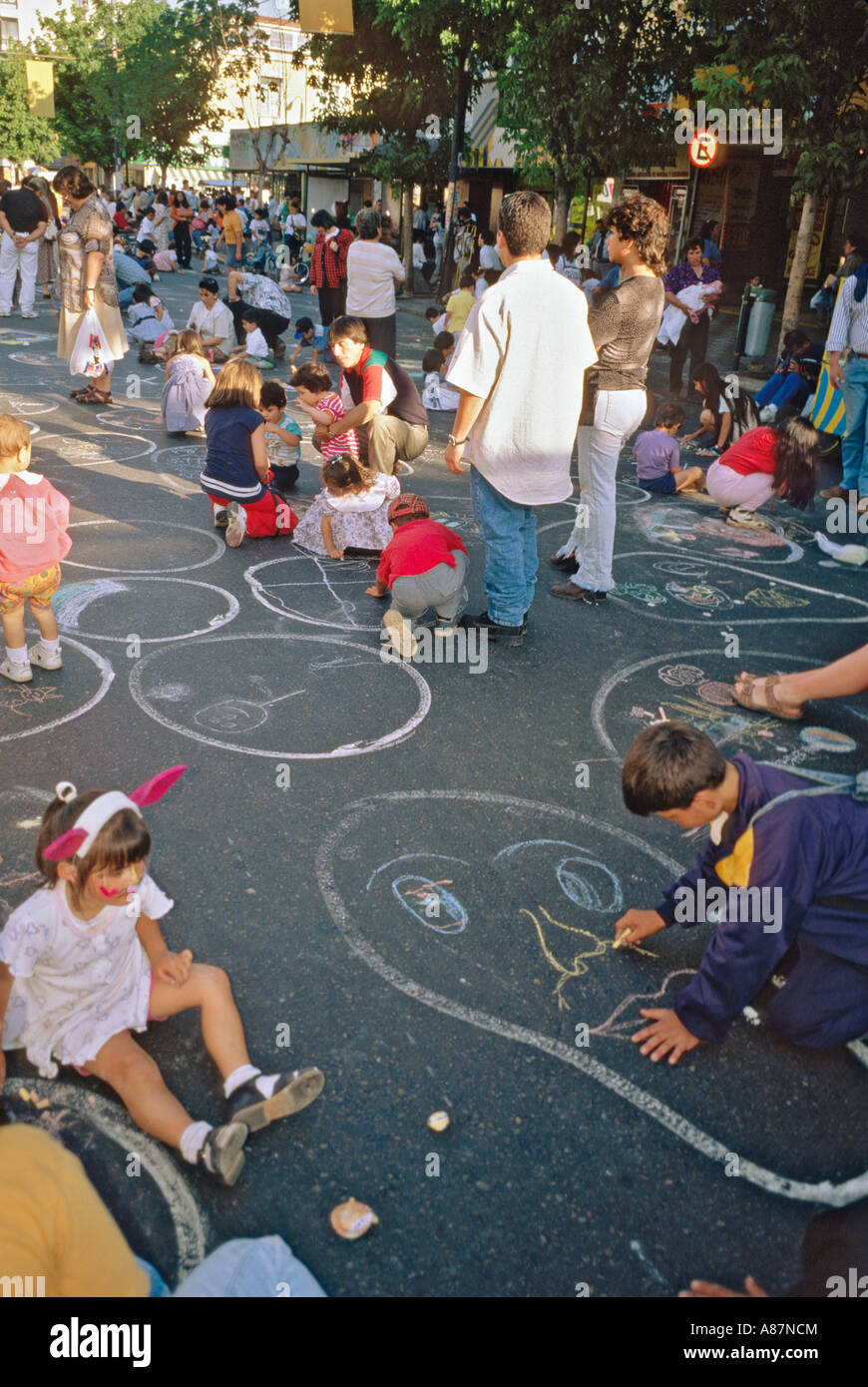 Children drawing on the street with chalk at a festival in downtown ...