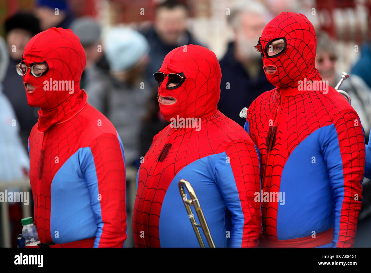 Clowns and a marching band of Spidermen march thorugh the town of ...