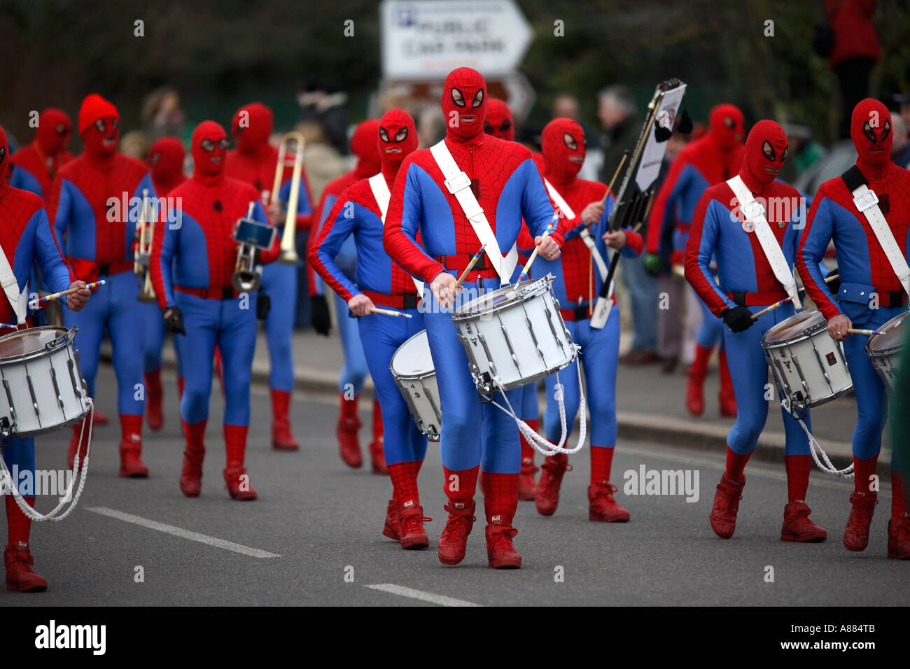 Clowns and a marching band of Spidermen march thorugh the town of ...