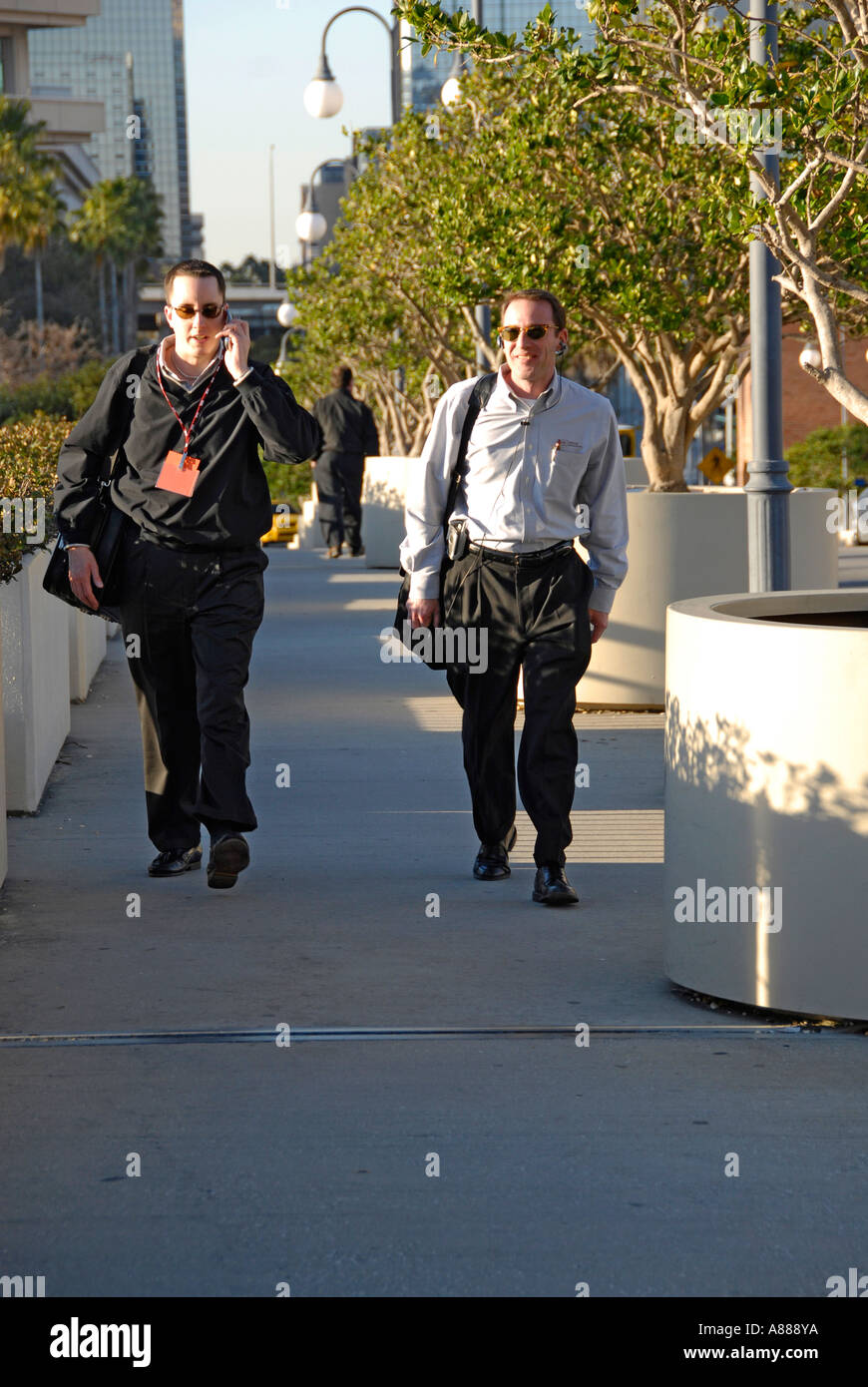 Professional man walking with laptop computer while talking on a ...
