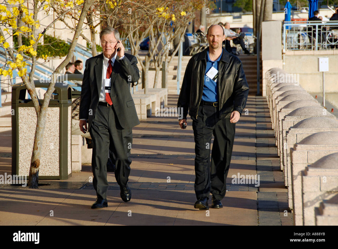 Professional man walking with laptop computer while talking on a ...