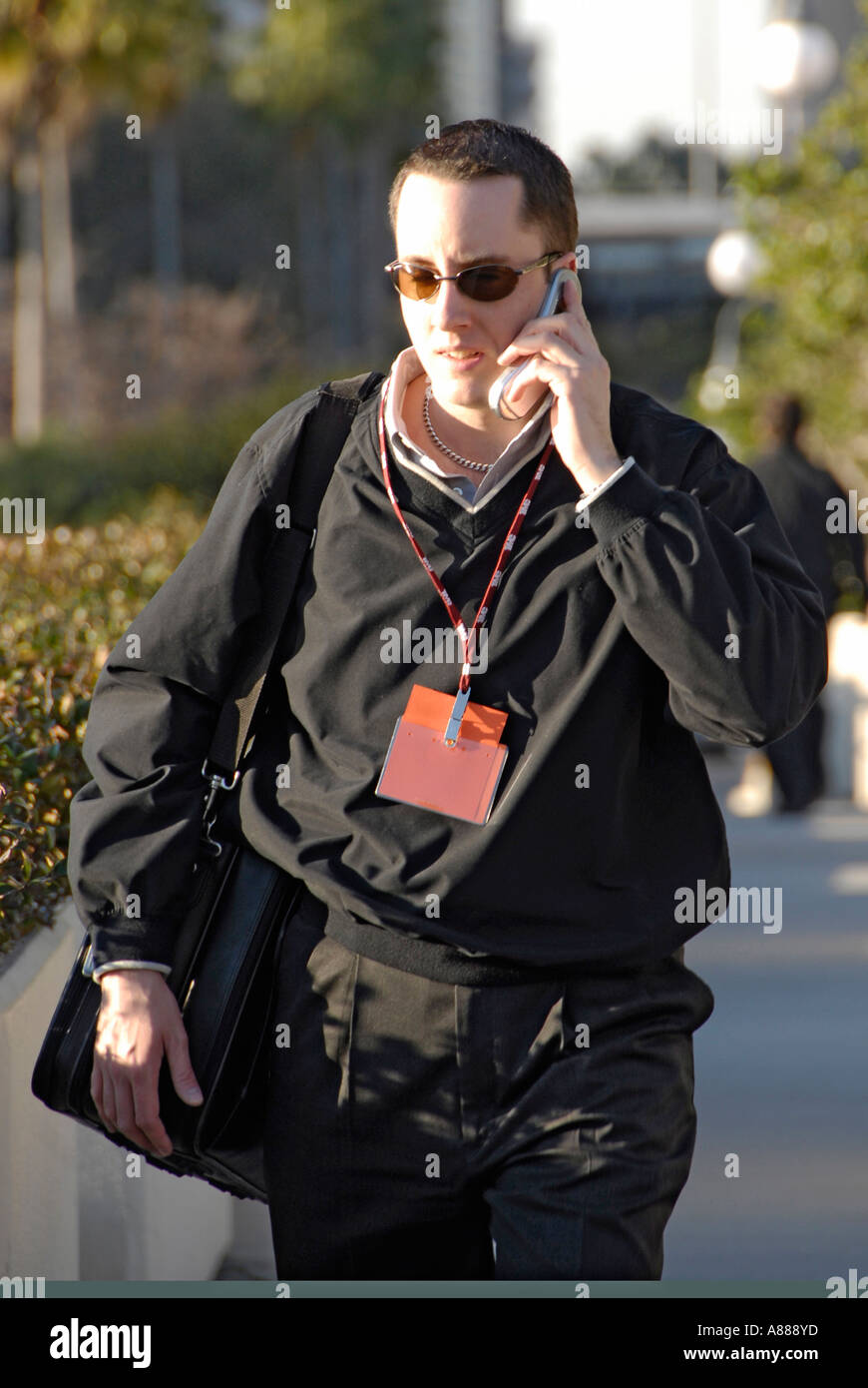 Professional man walking with laptop computer while talking on a ...